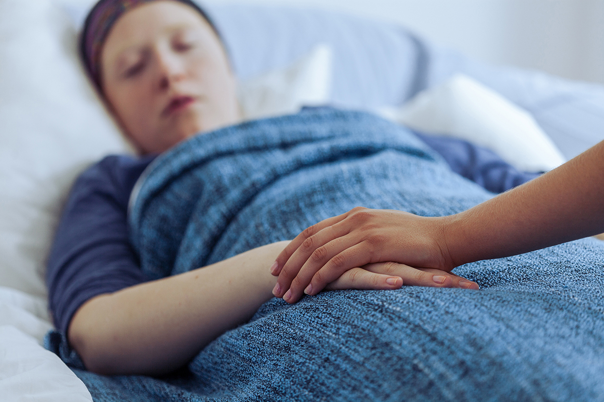Sick young girl suffering from lungs cancer with friend supporti